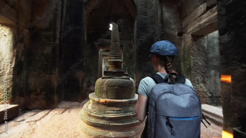 Caucasian woman with backpack is exploring Preah Khan and central stupa ...