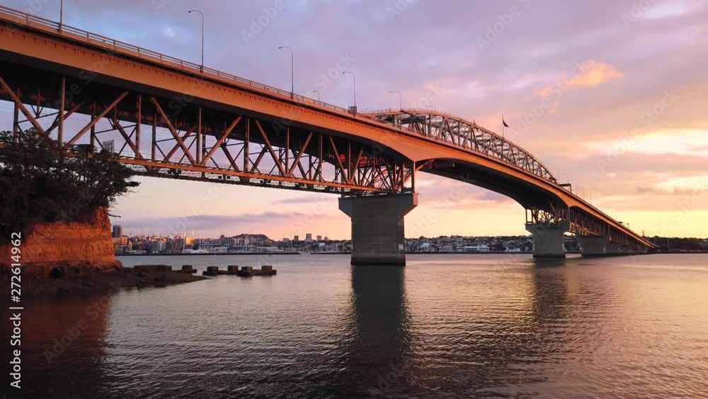 The Auckland harbour bridge glows during golden hour in Auckland city ...