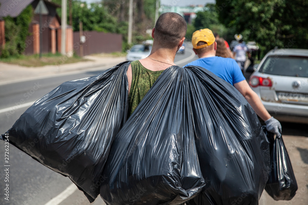 man with bags of muslin. Garbage collection in the street. Throw trash ...