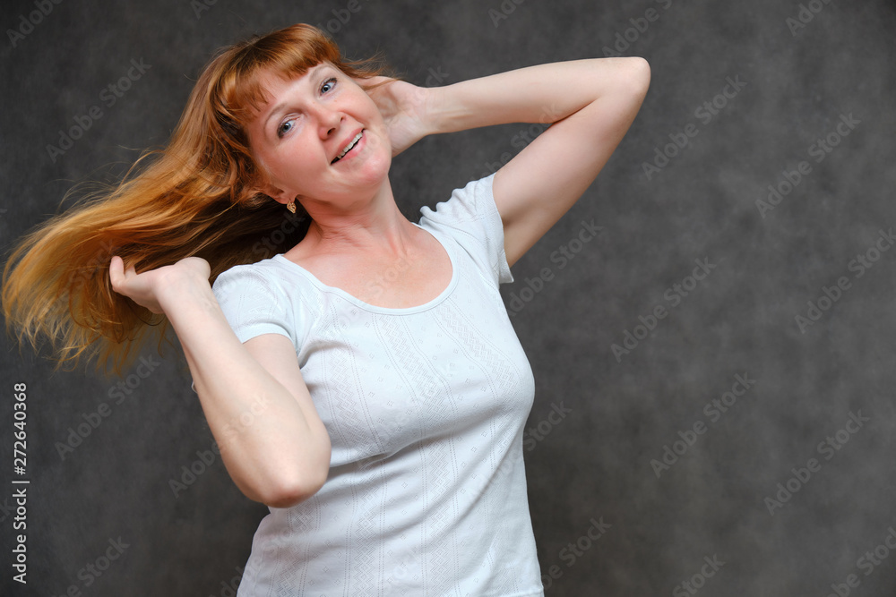 Studio portrait of a beautiful pretty woman age of 40 years on a gray ...