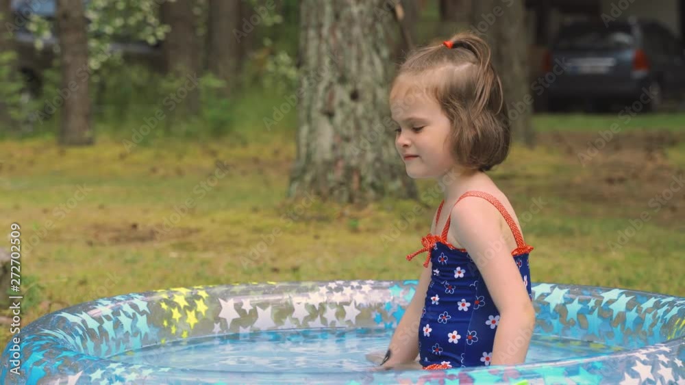 Little cute girl bathes in the pool in the garden on summer day Stock ...