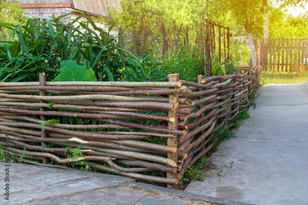 Wood wicker fence from curved wooden twigs. Wooden fence. Landscape ...