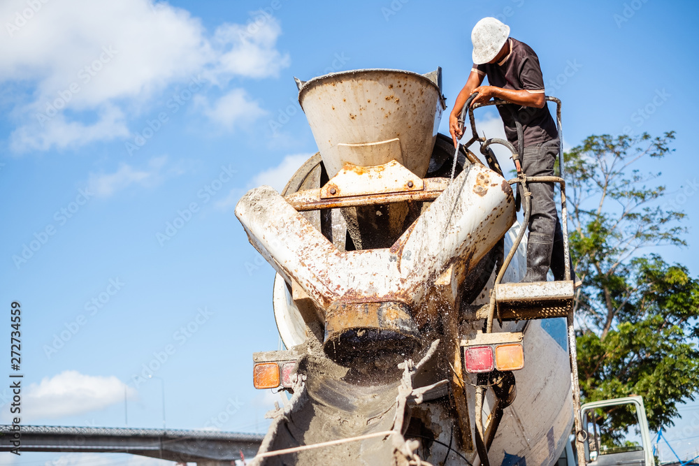 Truck driver washing the cement mixer truck with water jet after finish ...