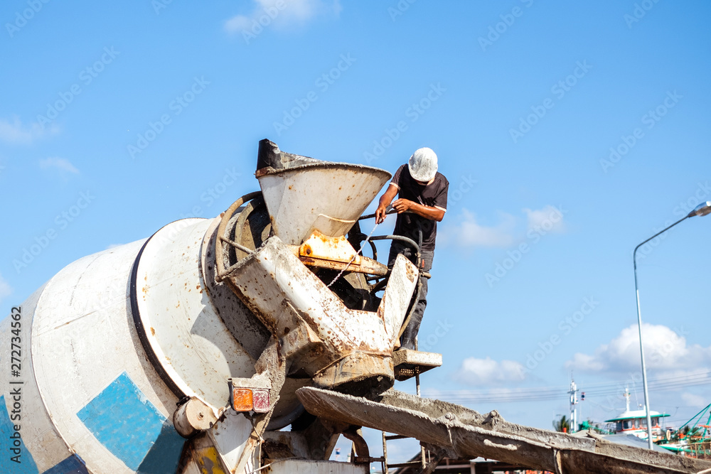 Truck driver washing the cement mixer truck with water jet after finish ...