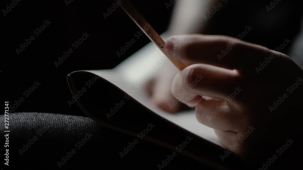 Close-up man's hand knocks nervously on the notebook with pencil and ...