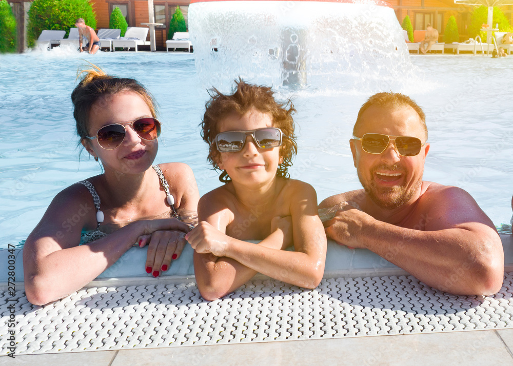 Happy family in the pool, having fun in the water, mother with three ...
