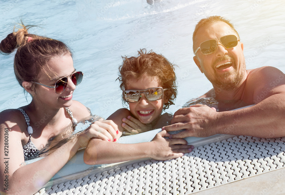 Happy family in the pool, having fun in the water, mother with three ...