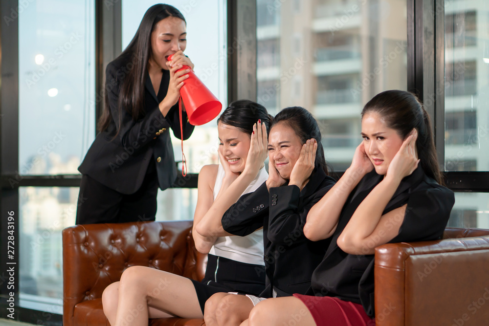 Angry young woman boss yelling through a megaphone to scream at ...