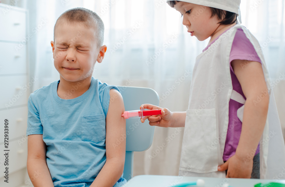 Children play in the hospital. The girl is dressed in a doctor 4 years ...