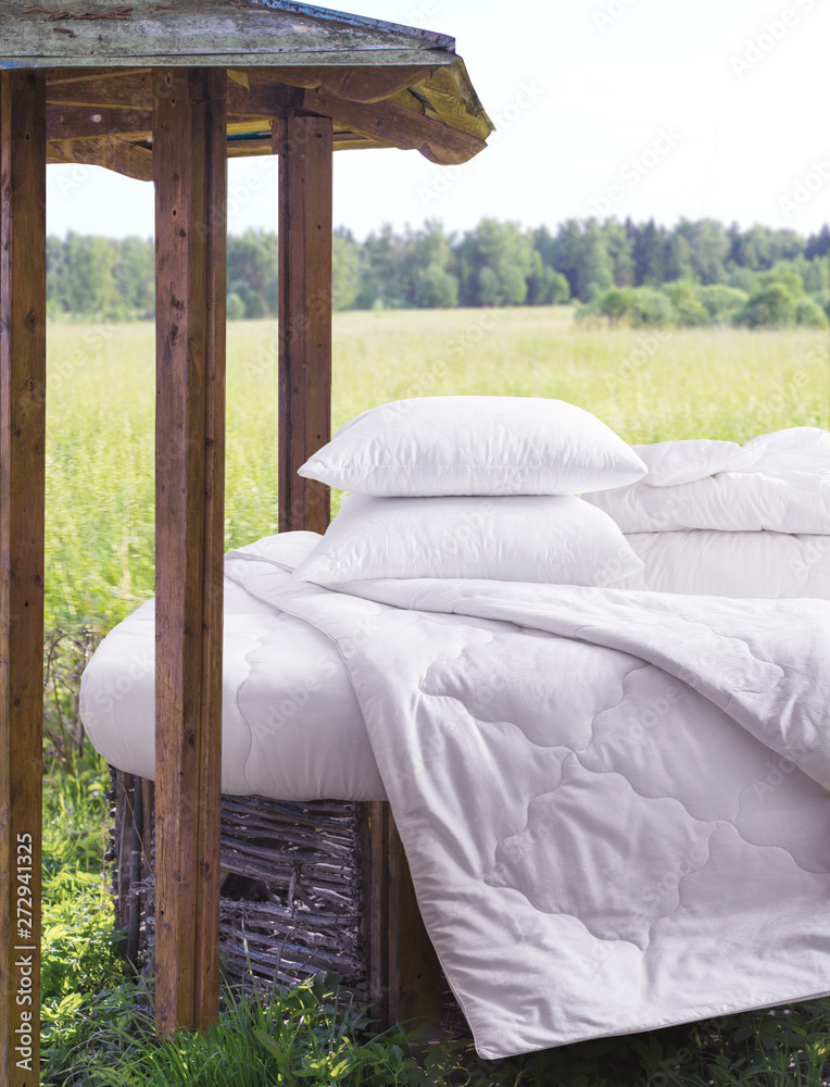 Bed with bed linen in the nature. Snow-white bed against a beautiful ...