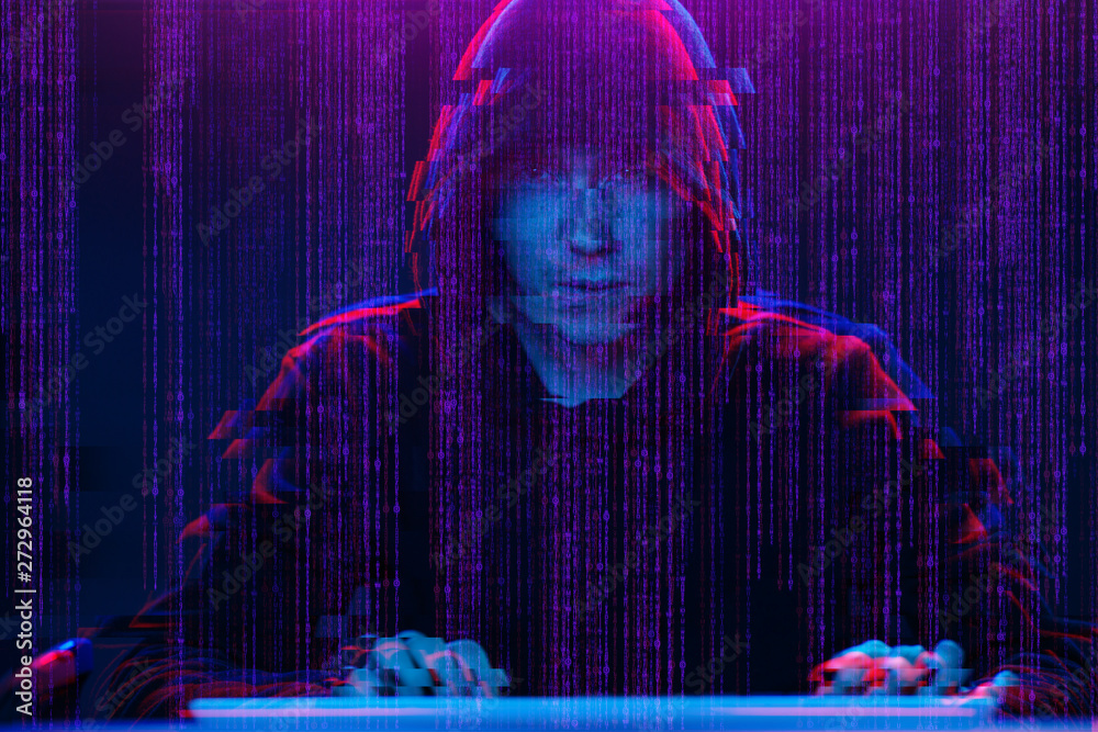 Hacker working with computer in dark room with digital interface around ...