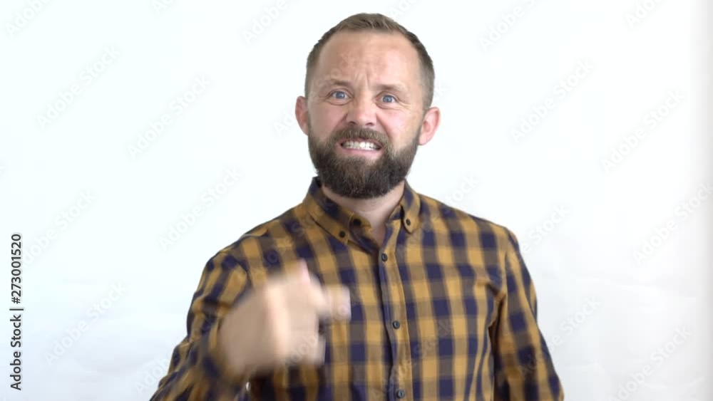 close-up of a bearded man with an angry face in a plaid shirt on a ...