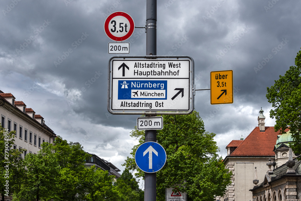 Germany, Munich: A couple of traffic signs on a lamp post in the city ...