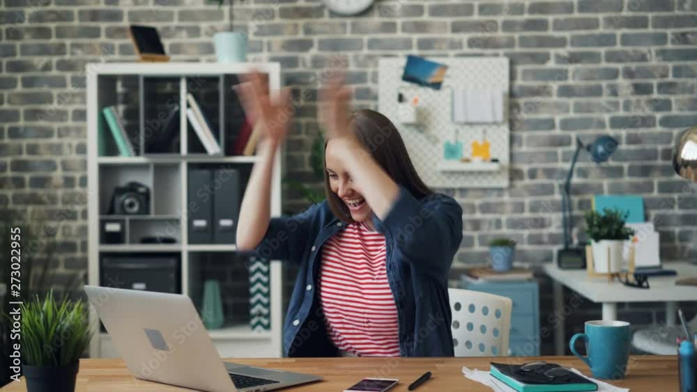 Cheerful office worker is using laptop typing then laughing enjoying ...