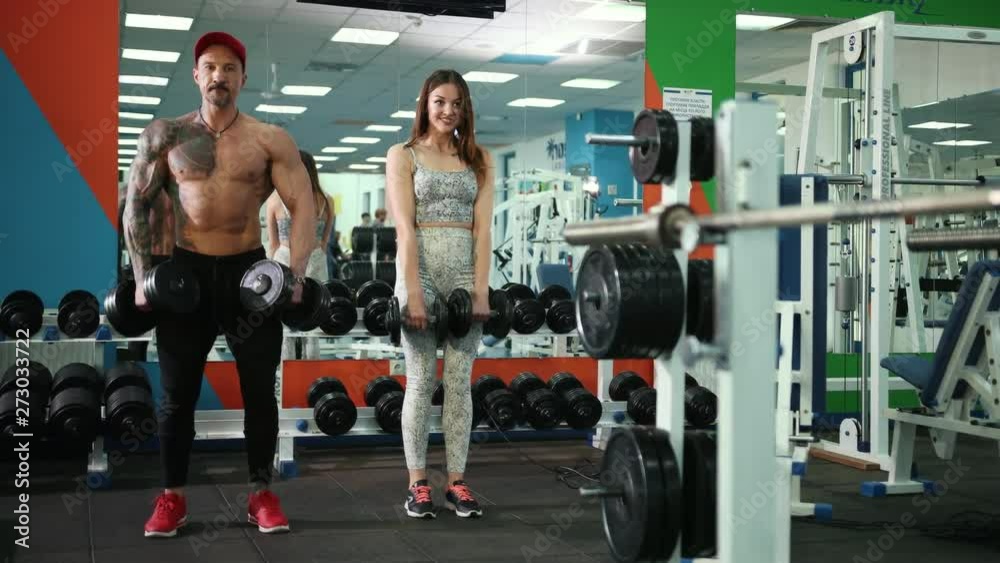 Man and woman flexing arms simultaneously by lifting dumbbells, workout ...