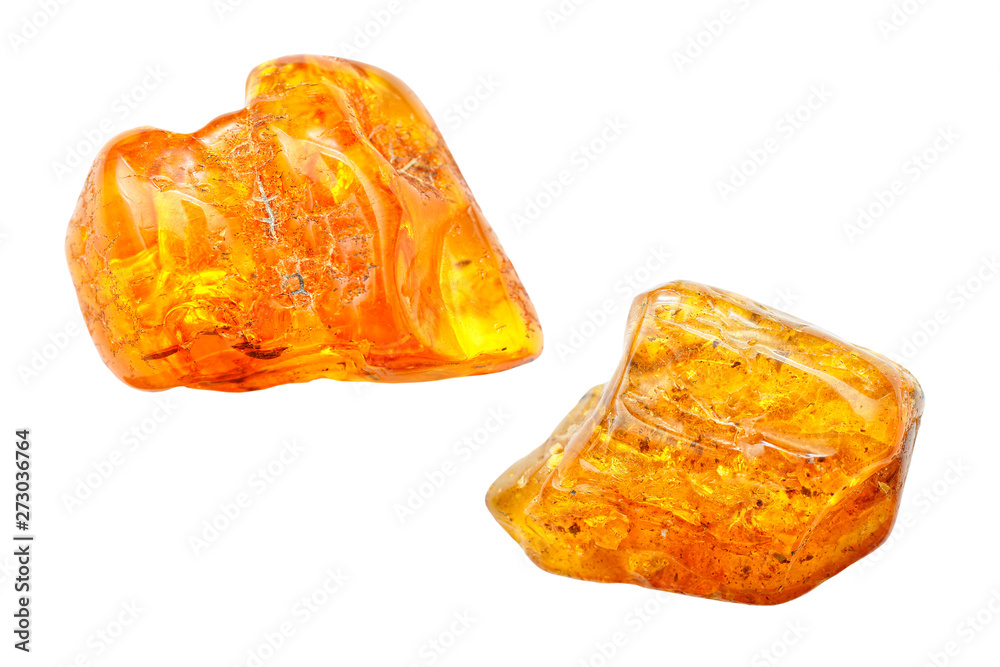 Two yellow transparent pieces of amber on a white background. Sun stone ...