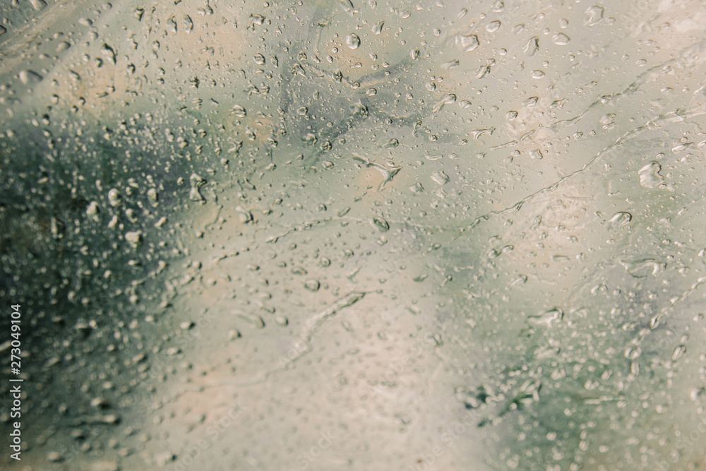 water droplets on translucent, misted glass. Spring rain drops on ...