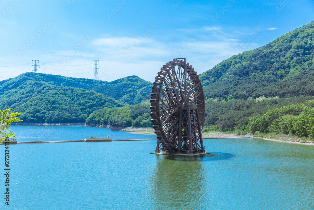 Large wooden waterwheel and blue water, Xijiao National Forest Park ...