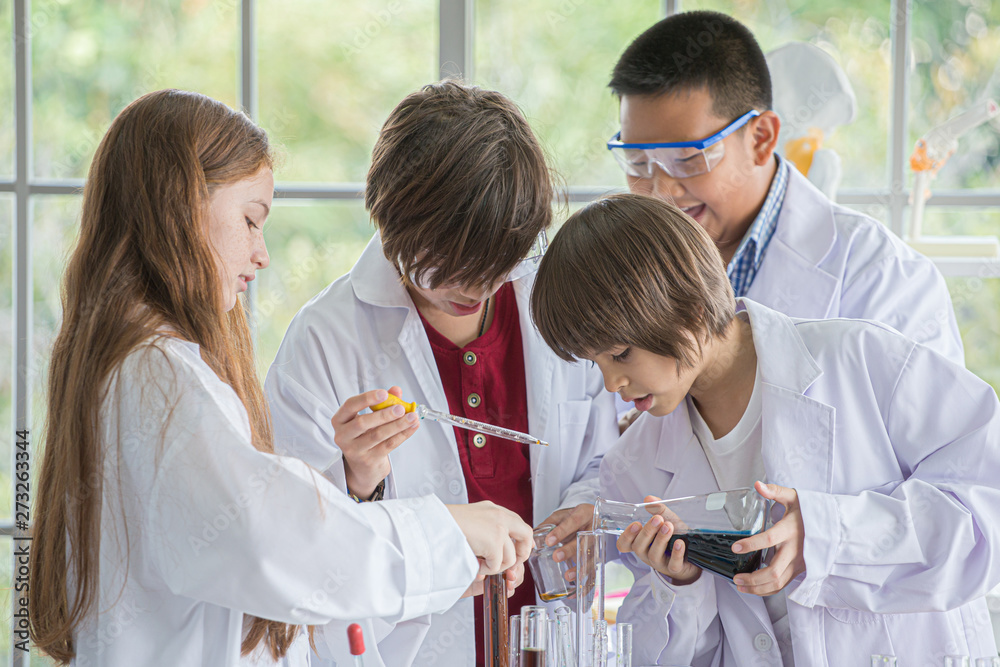 Group of Pupils in white gown doing a chemical experiment in laboratory ...