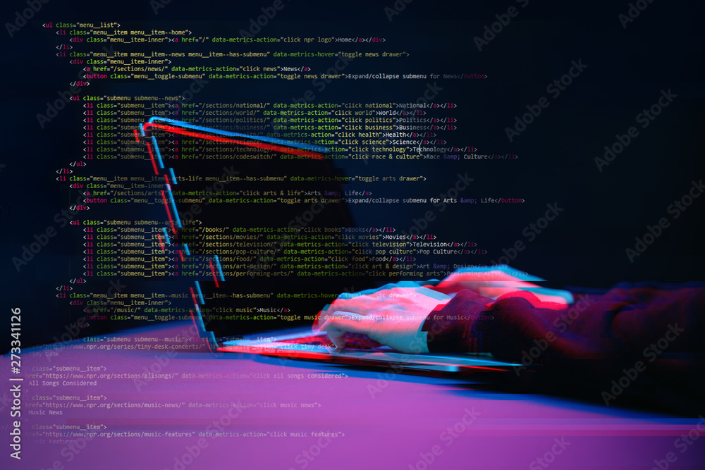Hacker working with laptop in dark room with digital interface around ...