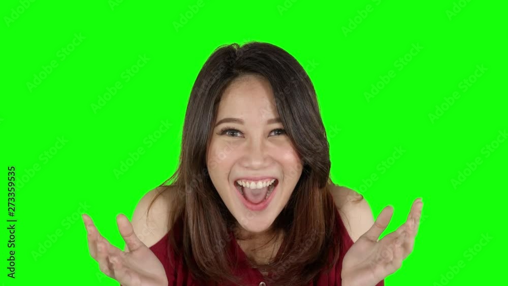 Excited young Asian woman looking at the camera in the studio. Shot in ...