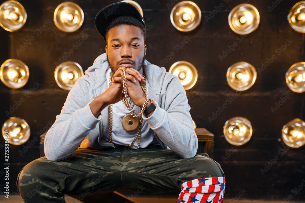 Black rapper in cap poses, perfomance on stage Stock Photo | Adobe Stock