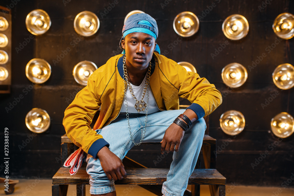 Black rapper in cap sitting on the steps Stock Photo | Adobe Stock