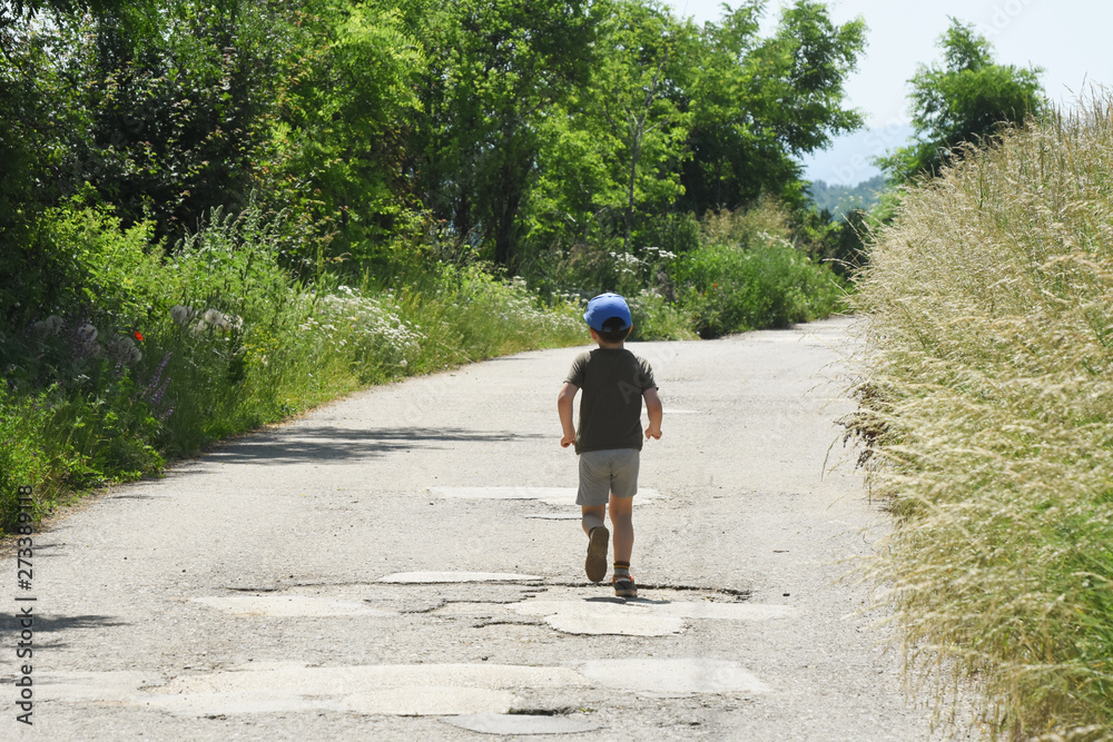 Child running in the street. Little boy running on the middle of the ...