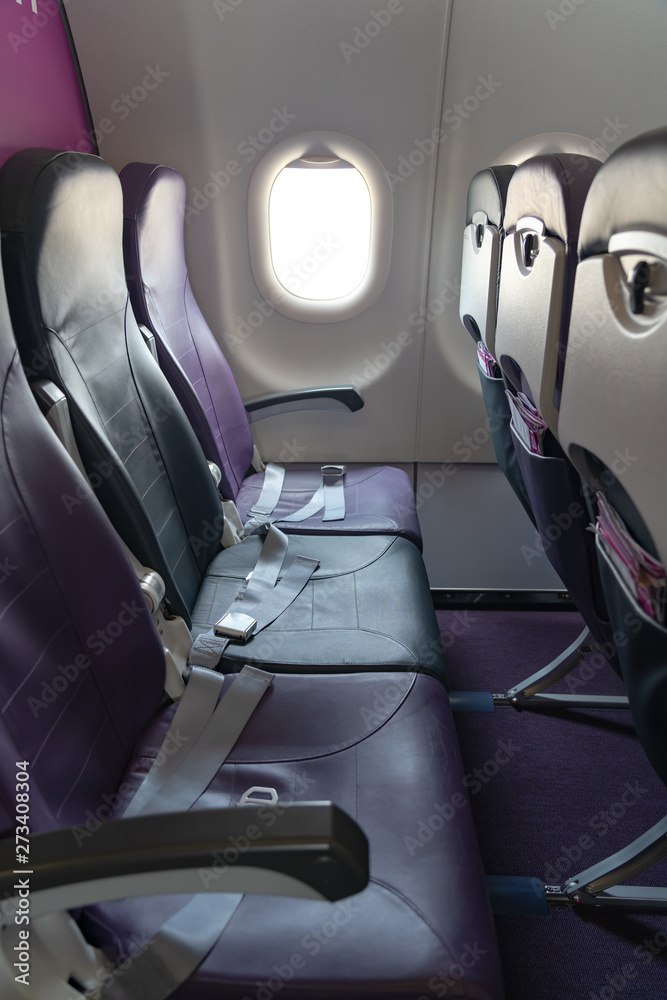 Airplane seats in the cabin economy class and the windows of the ...