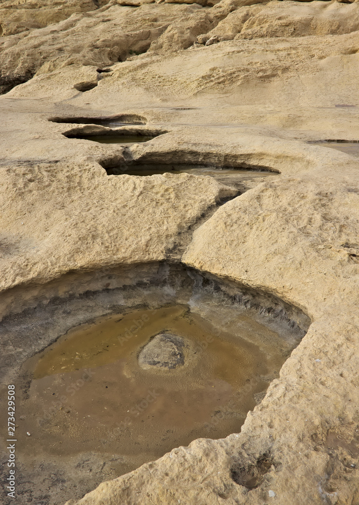 Little holes or pools of water formed in limestone at coast in Gozo ...