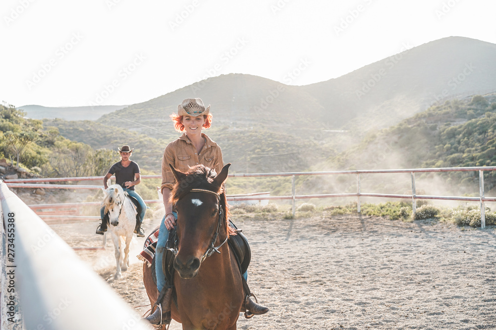 Young people riding horses inside corral - Wild couple having fun in ...