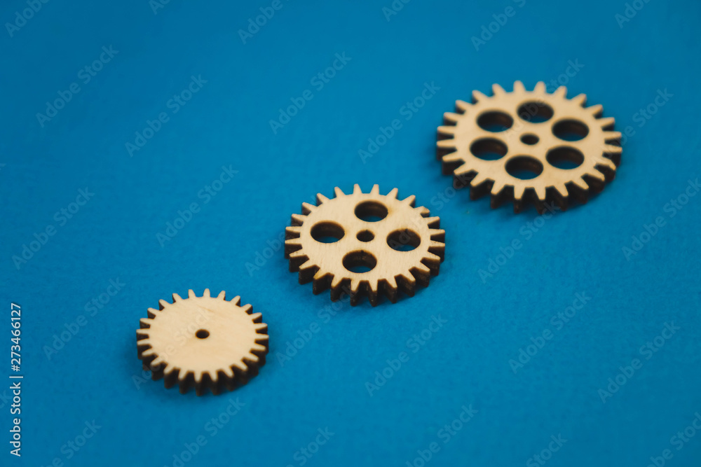 Wooden gear on a blue background. Abstract background for presentations ...