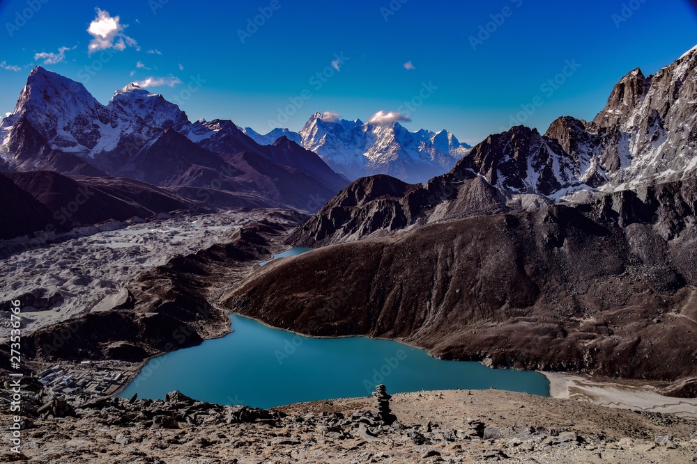 lake in the himalayan mountains of nepal with town on the left side ...