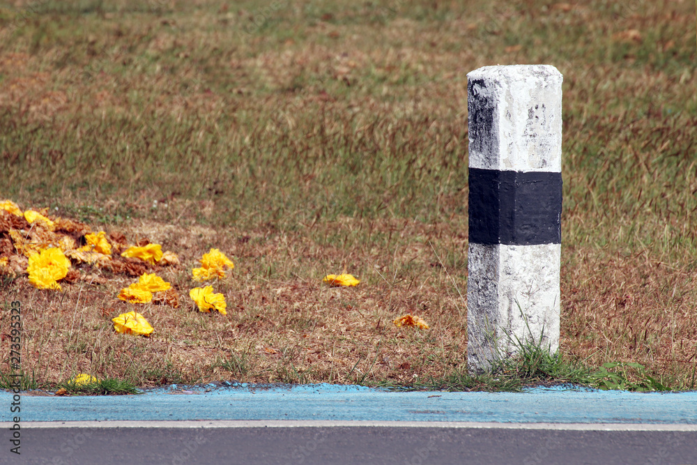 concrete kilometre sign pole on the roadside with nature grass ...