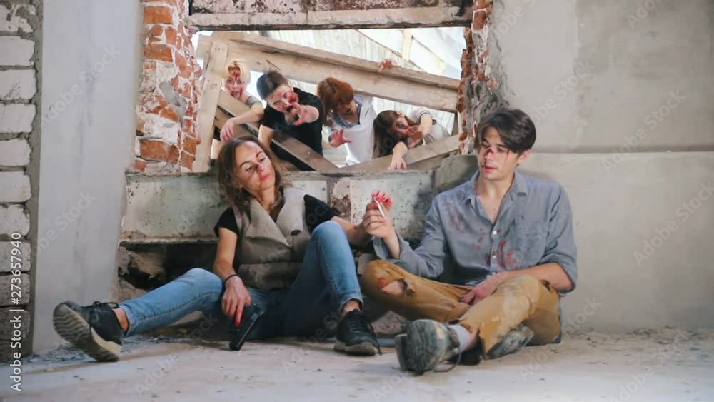 Doomsday, apocalypse. Two survived people sitting on the floor and ...