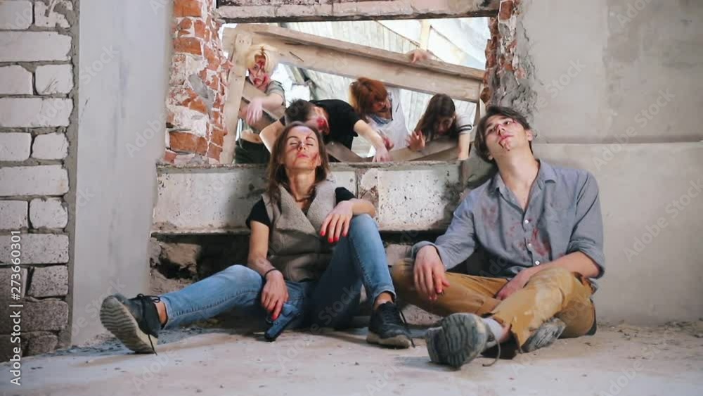 Doomsday, apocalypse. Two survived people sitting on the floor and ...