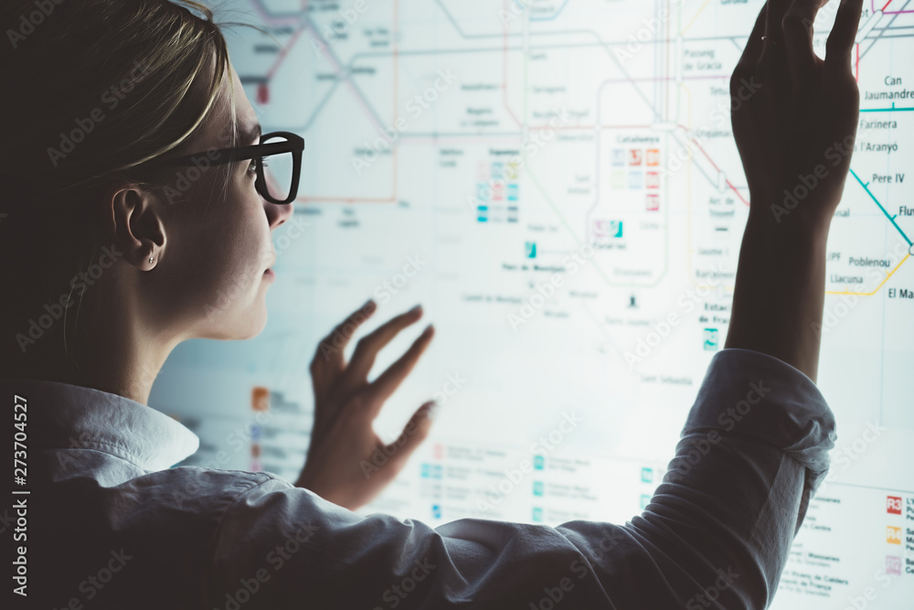 Digital monitor with public transport subway map. Female standing at ...