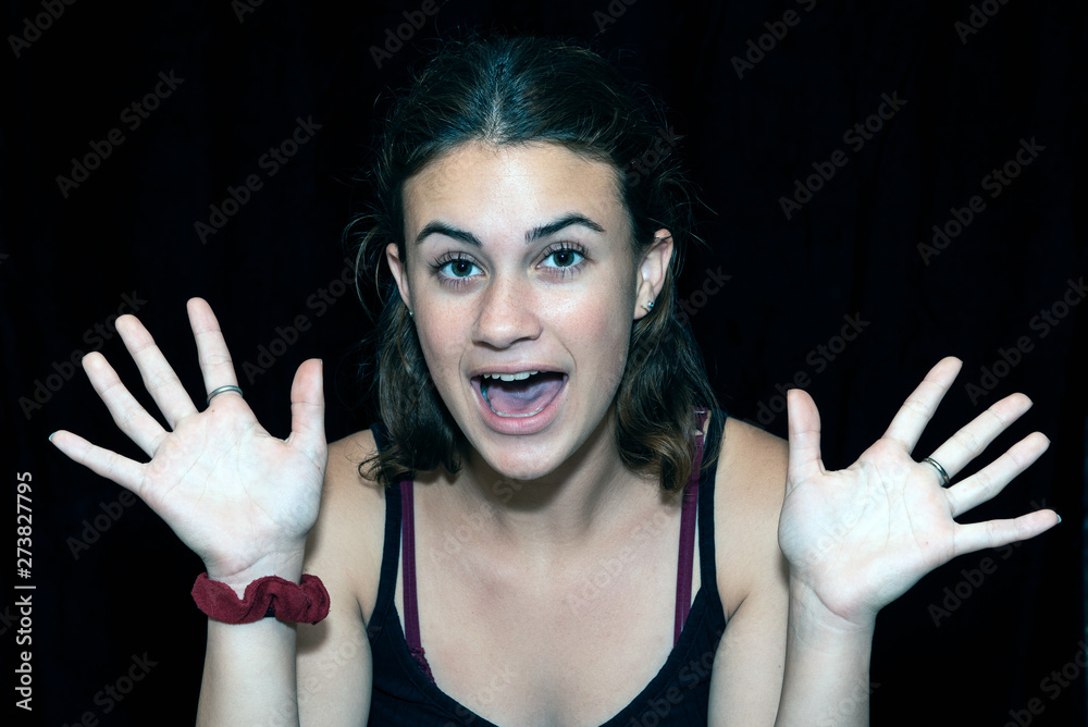 Surprised teenager girl reacting with hands up during night time. Stock ...