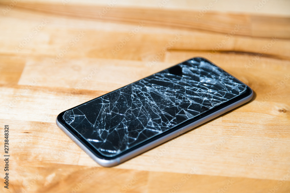 Concept of smart phone with broken screen. Top view on wooden desk ...