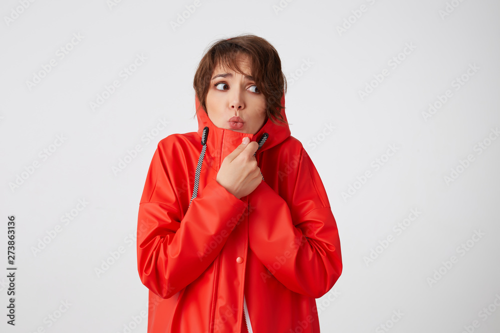Photo of beauty young frozen and scared short haired woman in red rain ...