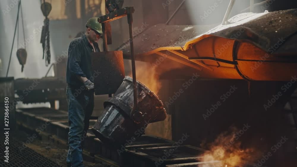 Hard work in the foundry. Pouring molten steel. Liquid steel pouring ...