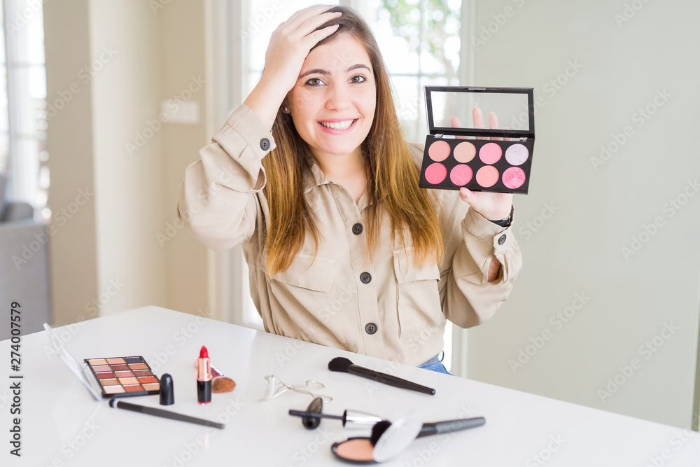 Beautiful young woman using make up cosmetics applying color from ...