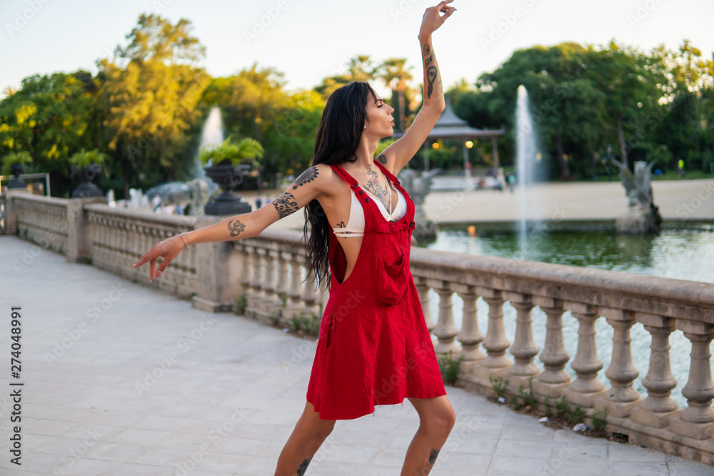 tattooed transgender model is dancing in the green park. Emotional ...
