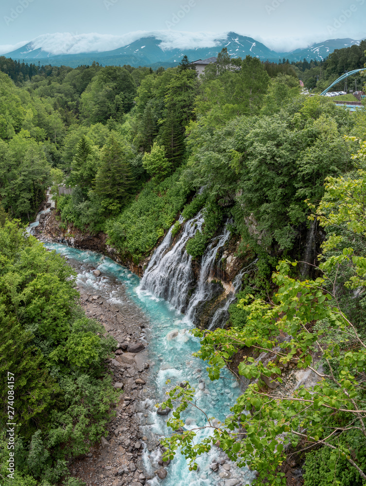 Scenery of shirahige's waterfall and Biei river. The water of this ...