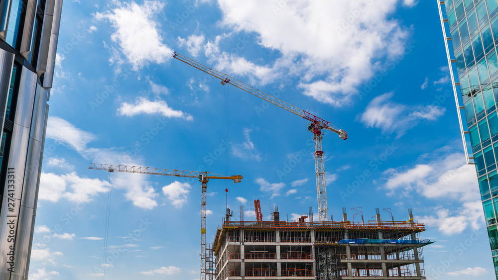 Skyscraper construction. Two tower cranes on blue sky background ...