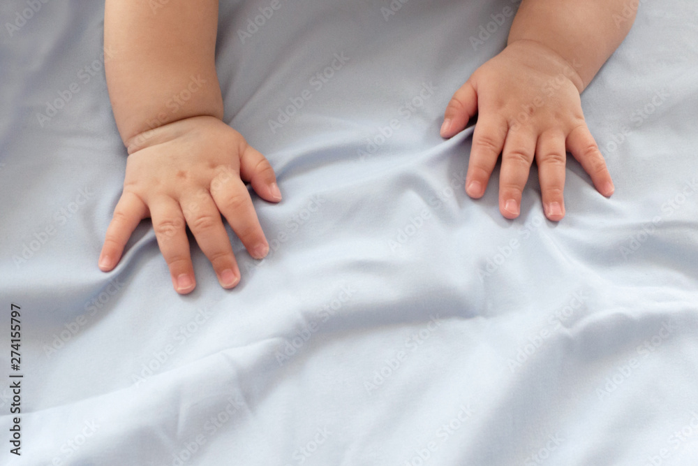 cute little baby boy hands are crawling and playing on the soft blanket ...