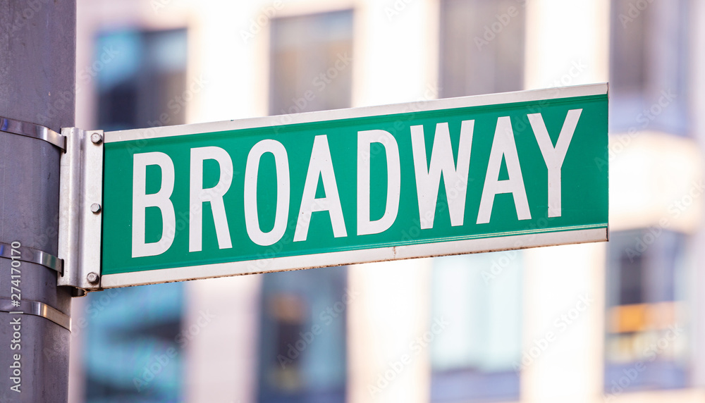 Broadway road sign. Blur buildings facade background, Manhattan ...