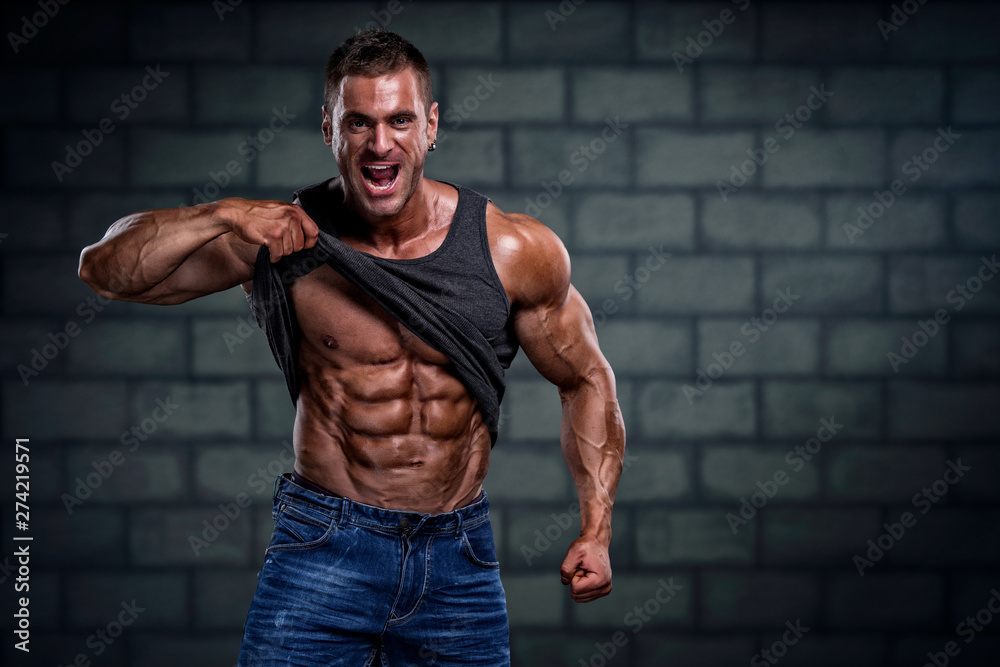 Handsome Bodybuilder Showing Abdominal Muscles Stock Photo | Adobe Stock