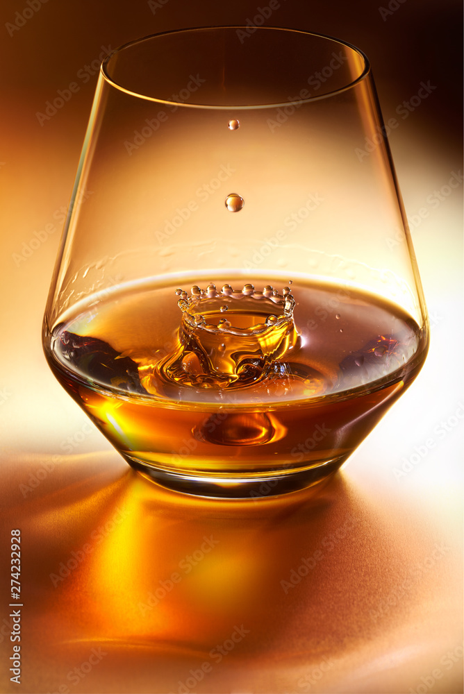 whisky drop falling into glass of whisky Stock Photo | Adobe Stock