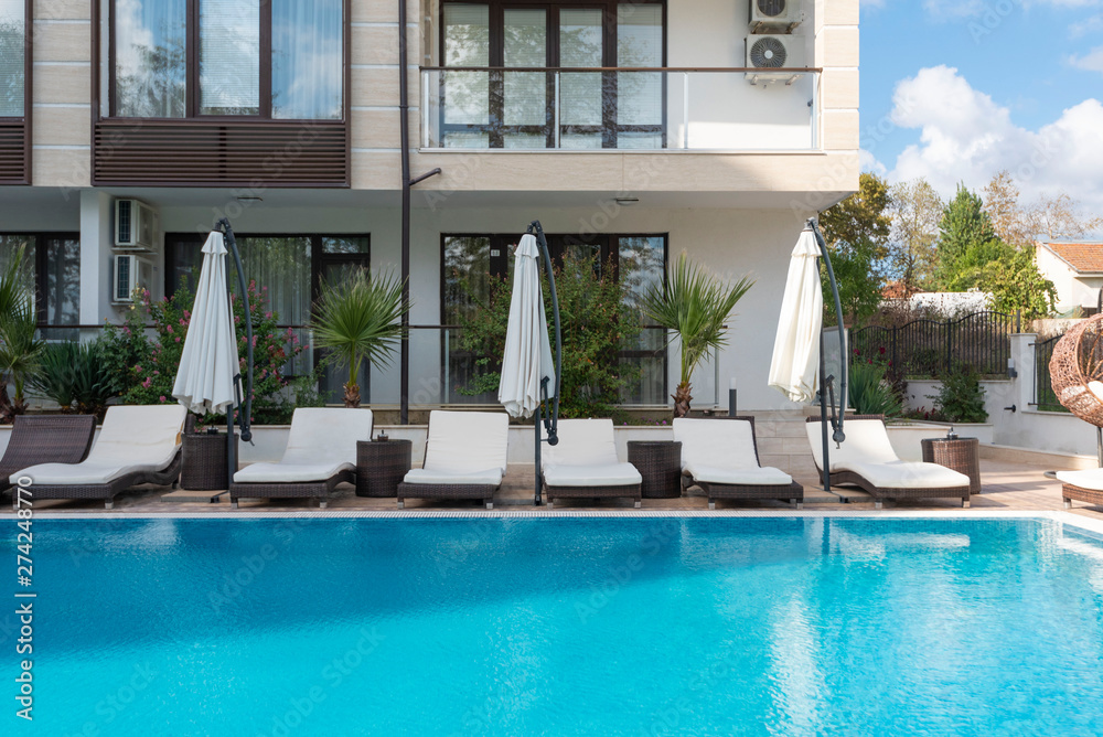 Summer vacation. Swimming pool of luxury hotel with umbrella and chair ...